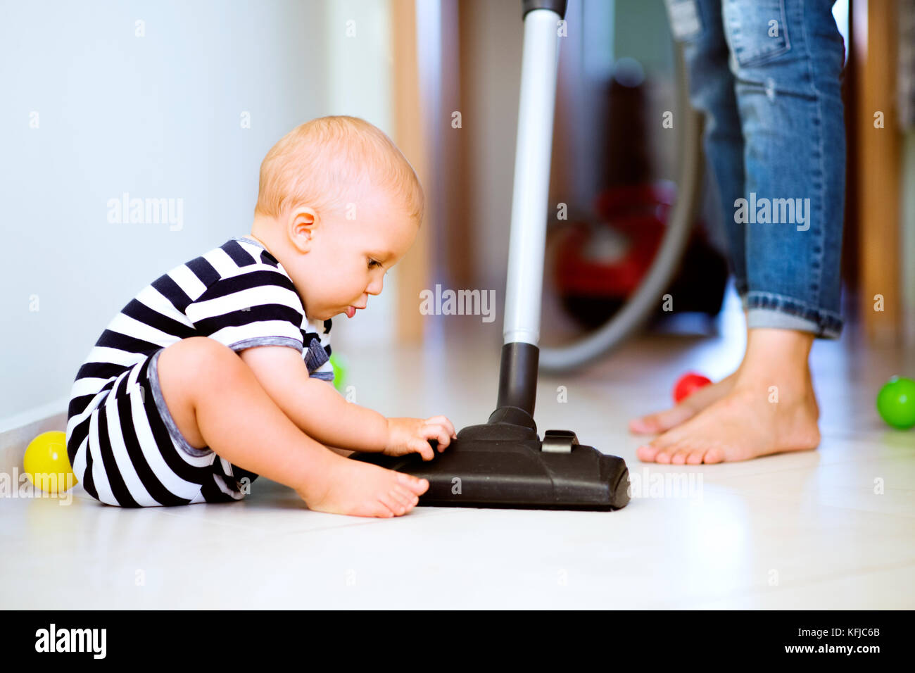 Young mother with a baby boy doing housework Stock Photo - Alamy