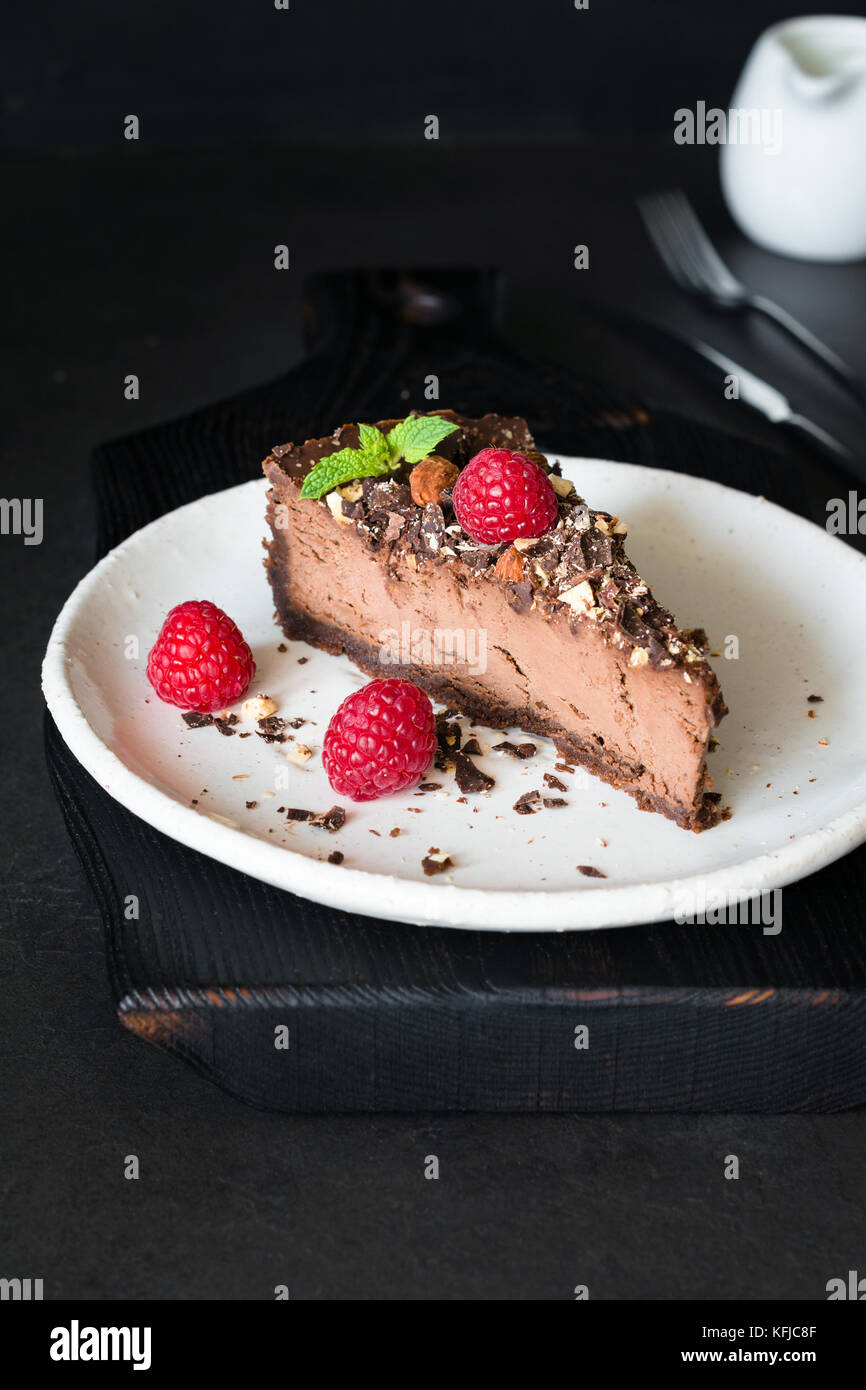 Slice of chocolate cheesecake decorated with almonds, raspberries and ...