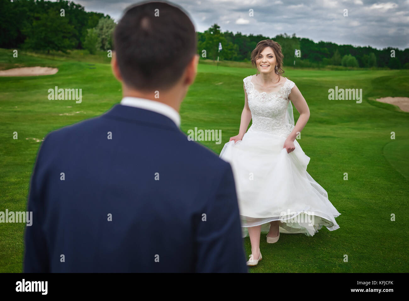 Happy bride running to meet her groom on a meadow Stock Photo - Alamy