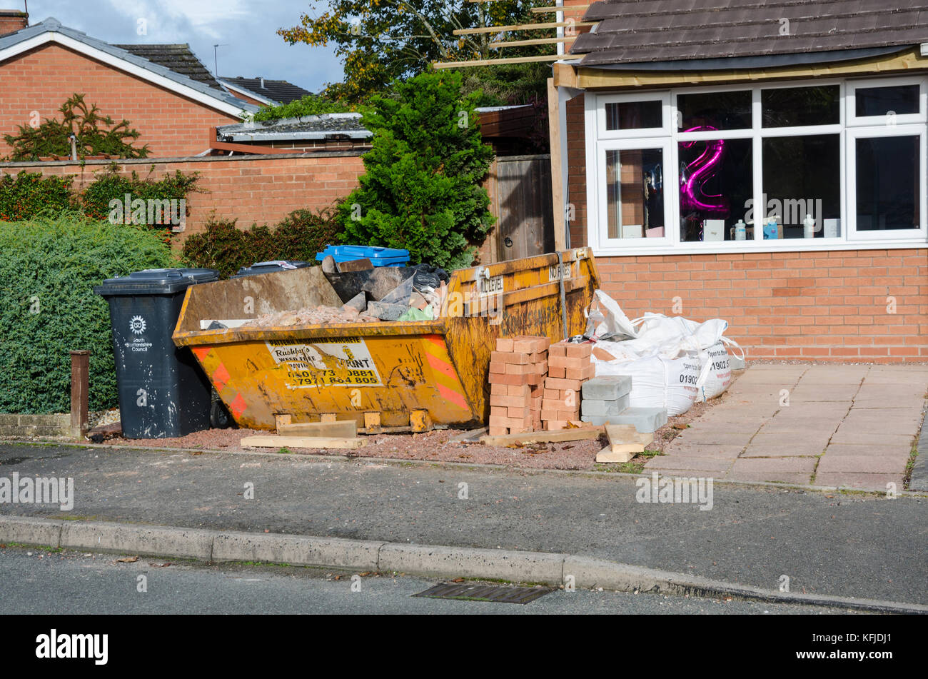 A skip left in a front garden for rubbish created as a result of home ...