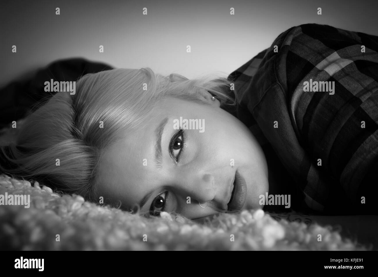 Portrait of young woman, lying down, closeup, looking directly at the ...