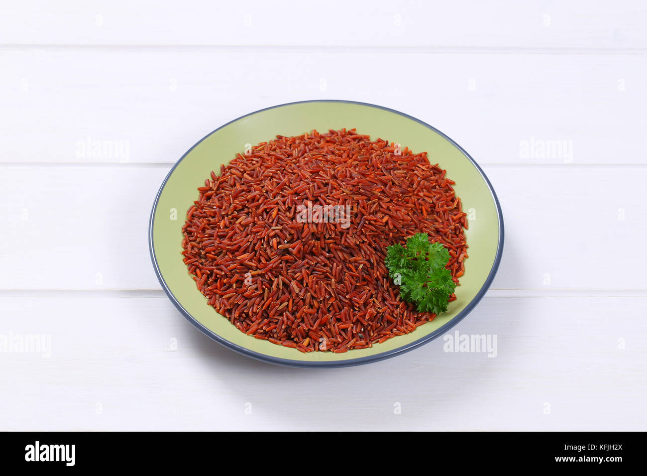 plate of red rice on white wooden background Stock Photo - Alamy