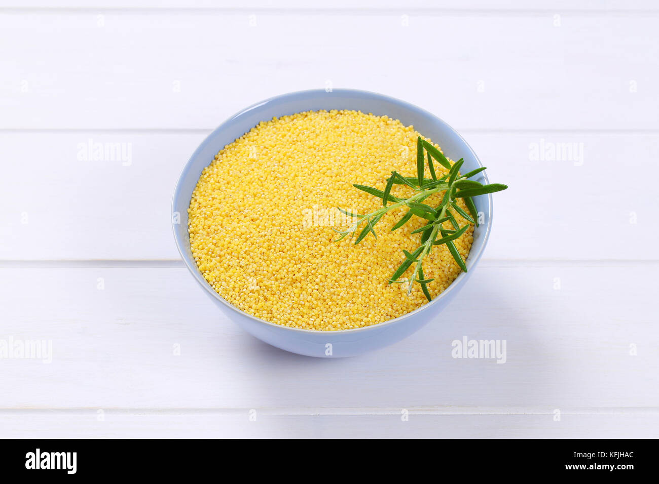 bowl of raw millet on white wooden background Stock Photo - Alamy