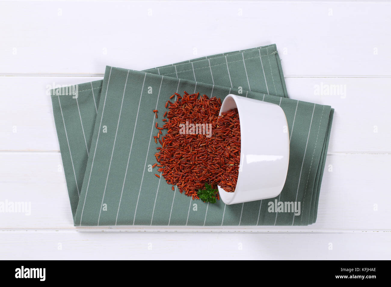 bowl of red rice spilt out on grey place mat Stock Photo - Alamy
