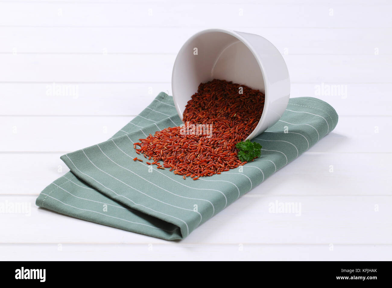 bowl of red rice spilt out on grey place mat Stock Photo - Alamy