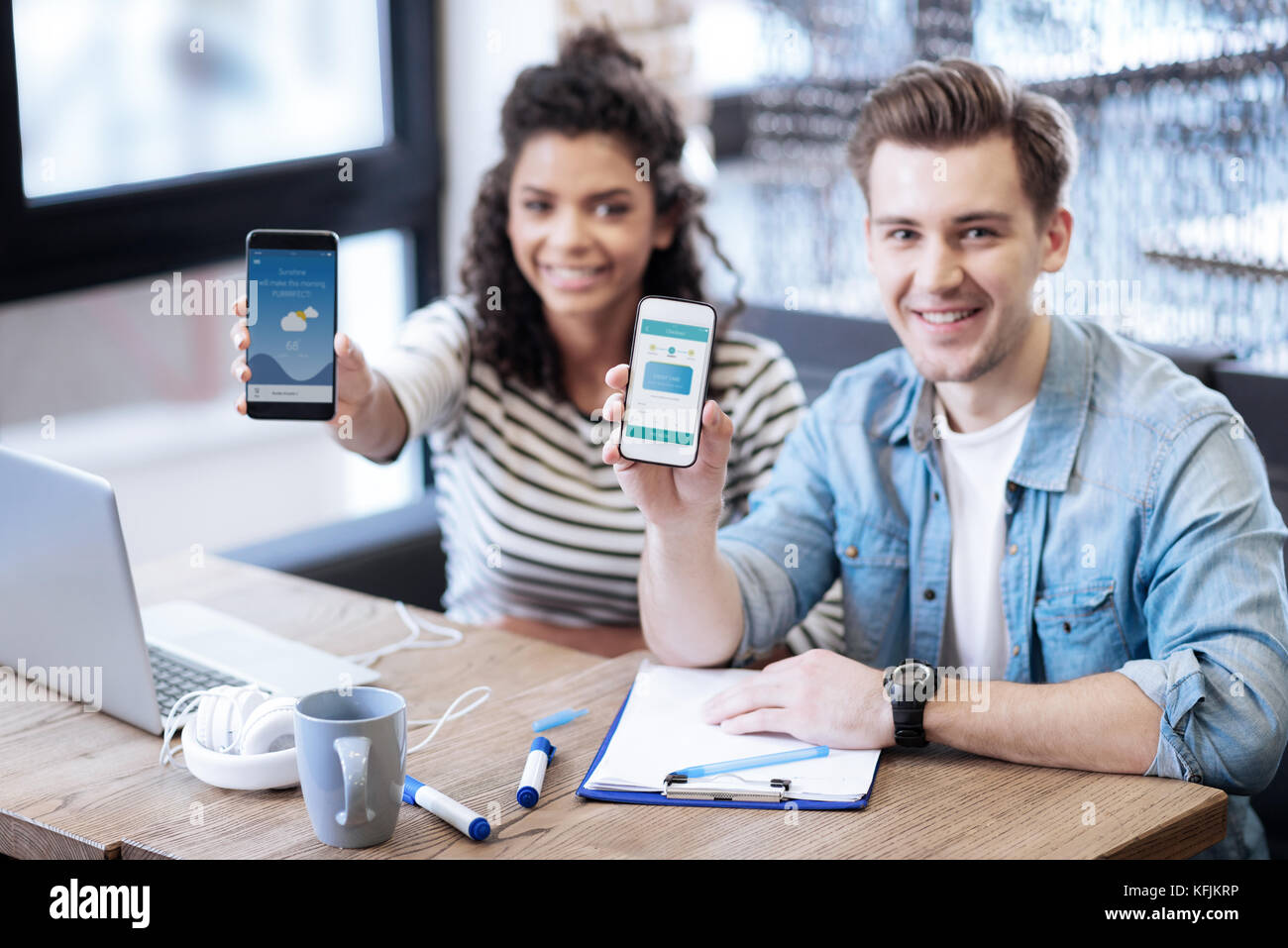 Lovely boy and girl showing screens of their phones Stock Photo - Alamy