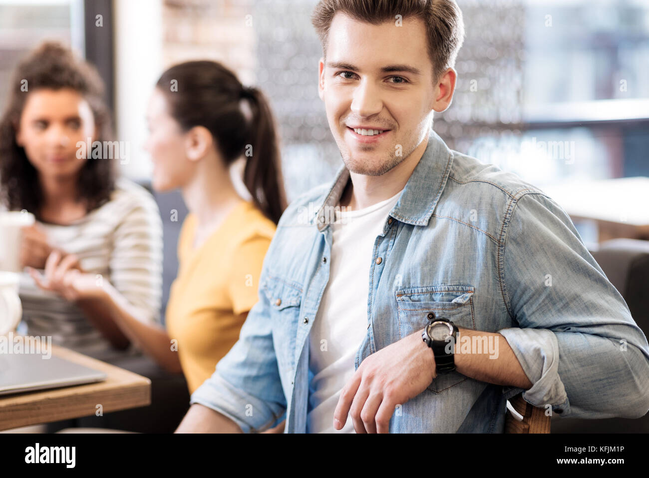 Joyful man smiling and sitting at the table Stock Photo - Alamy