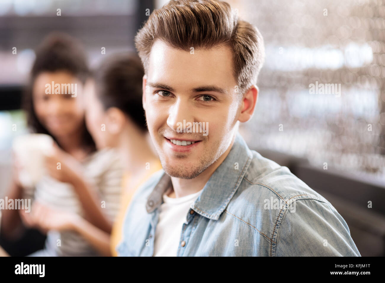Glad man smiling and sitting at the table Stock Photo - Alamy