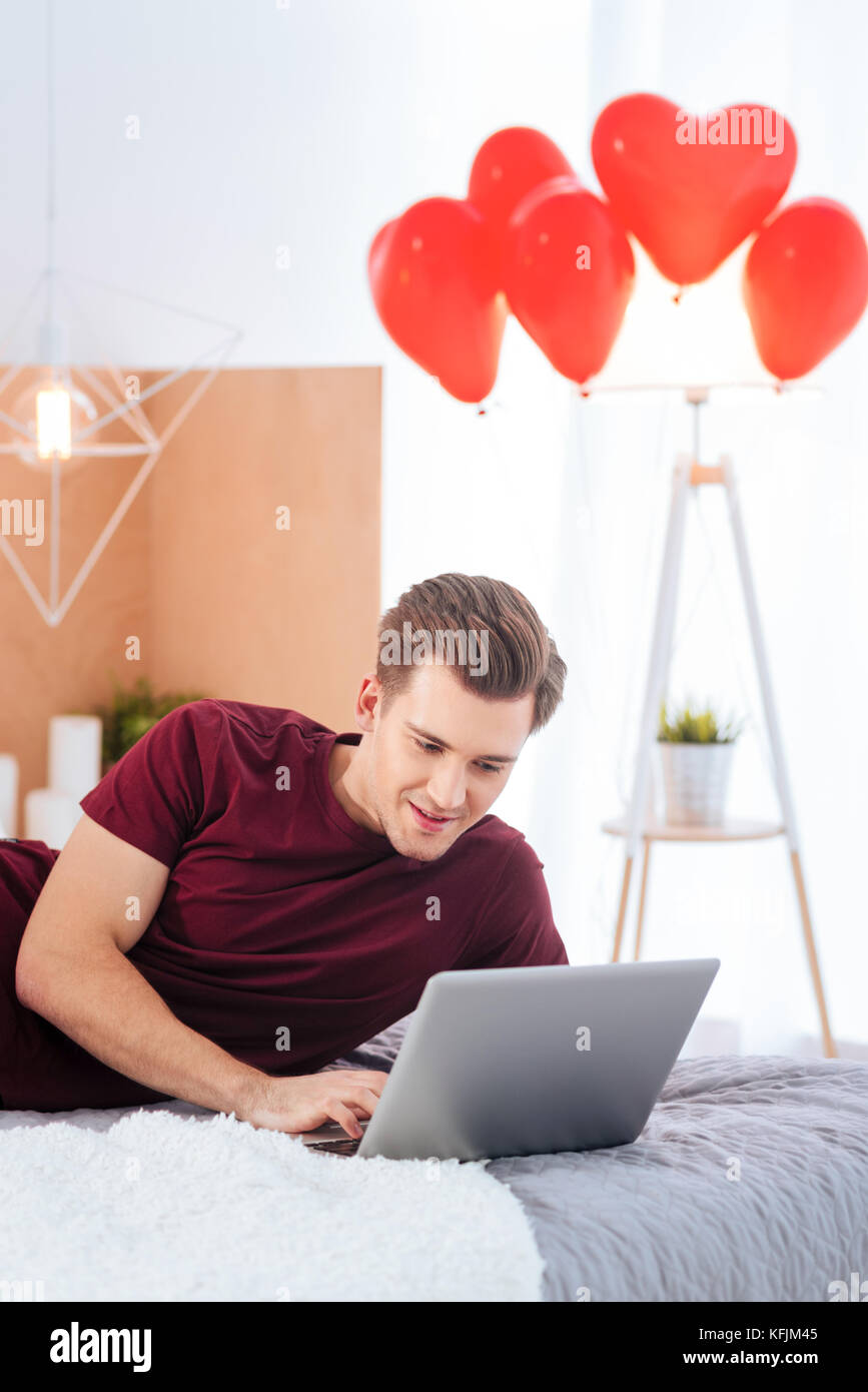 Charming guy using laptop at home Stock Photo - Alamy