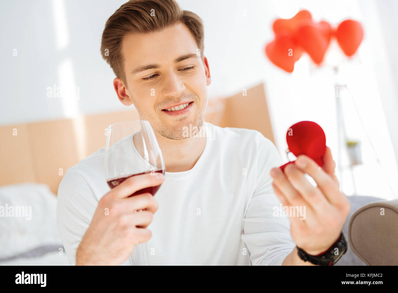 Relaxed young man looking at engagement ring Stock Photo - Alamy