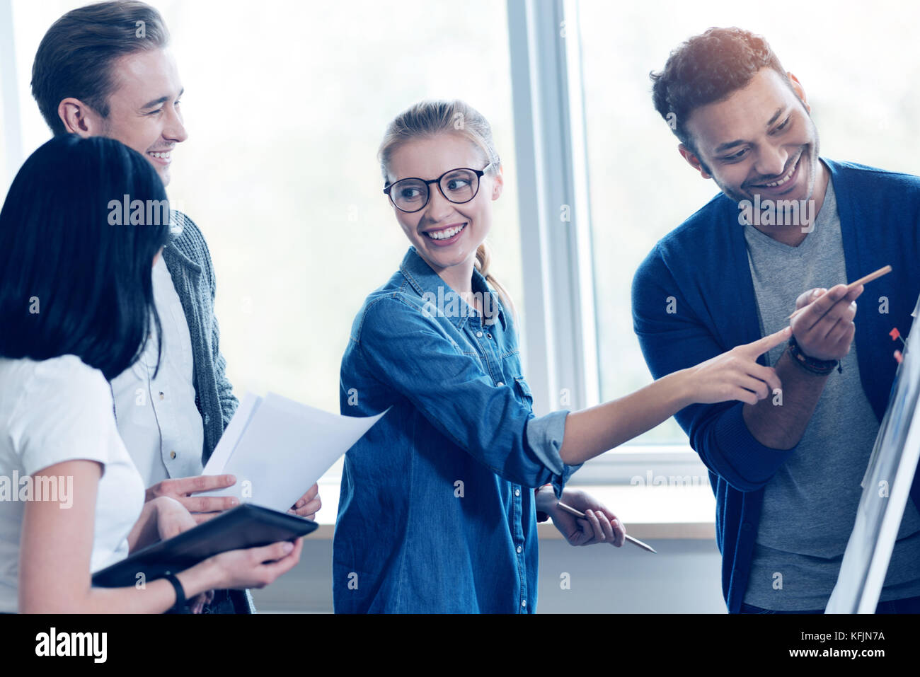 Smiling people looking at board with presentation Stock Photo - Alamy