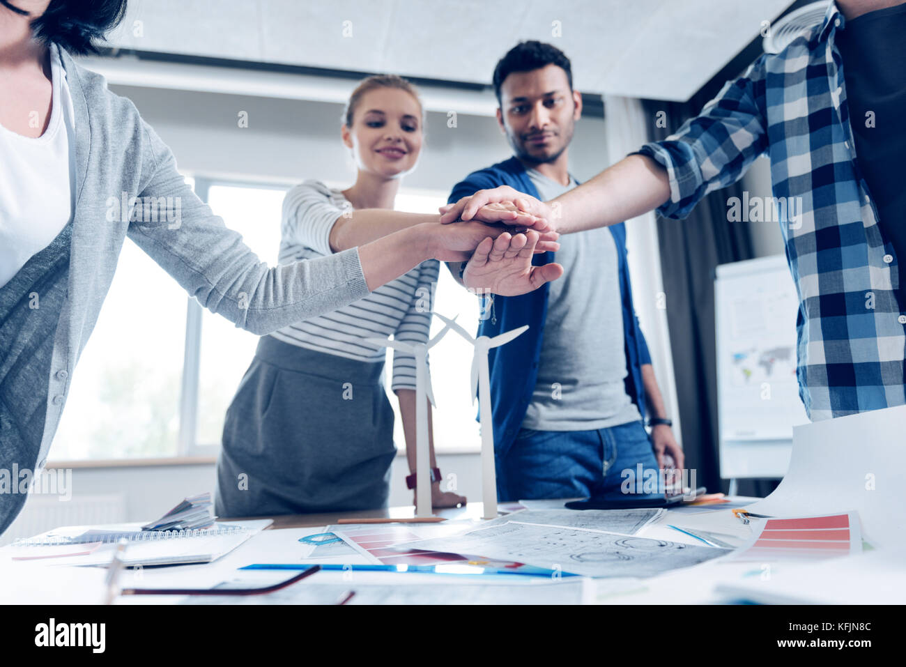 Attentive colleagues holding hands over table Stock Photo - Alamy