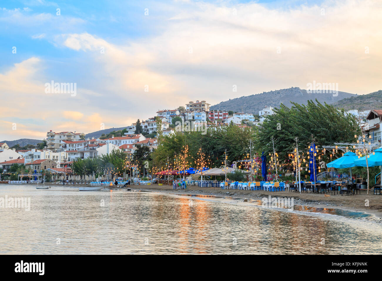 Datca beach with lantern lights on trees and reflection on sea during ...
