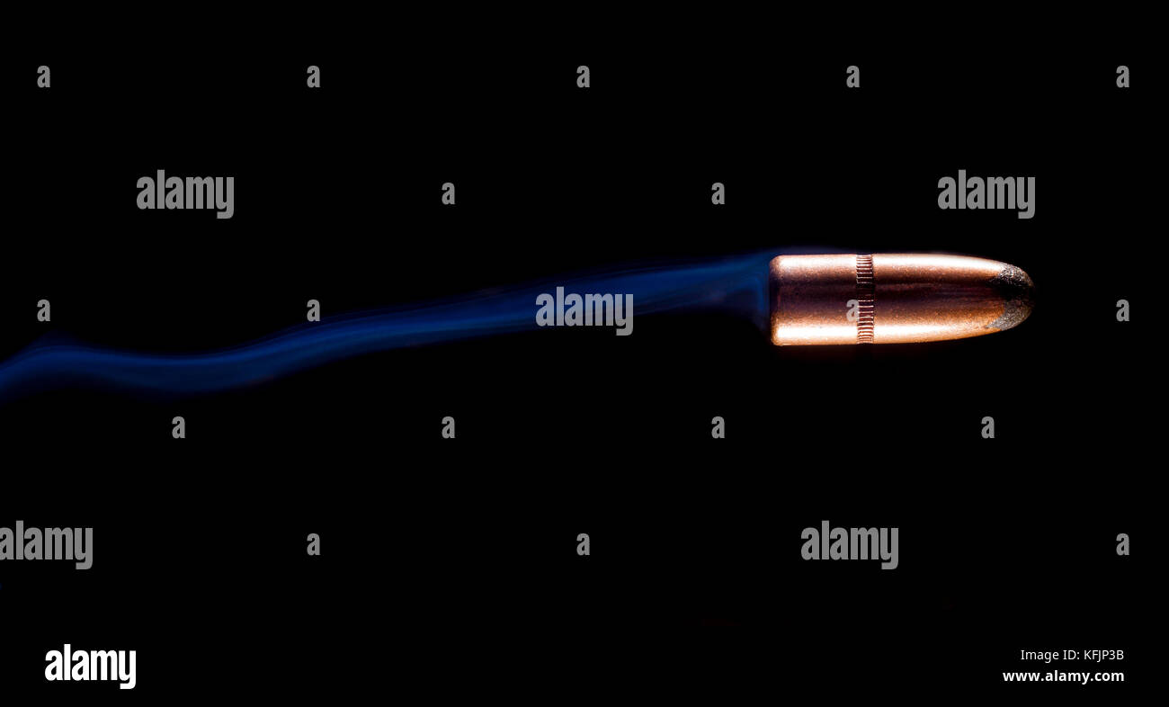 Copper plated bullet with blue smoke trailing behind Stock Photo - Alamy