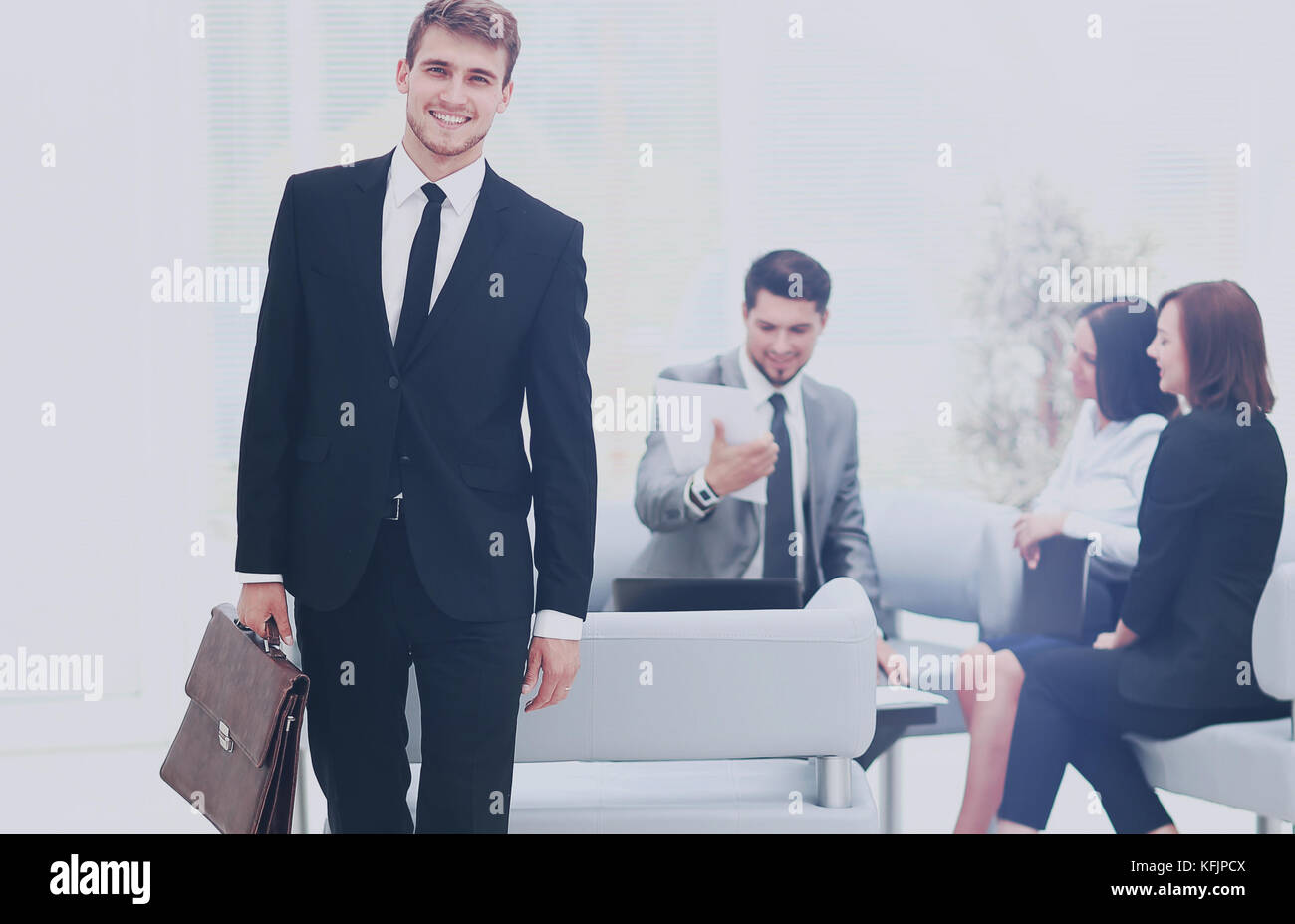 Successful business man standing with his staff in background at Stock ...