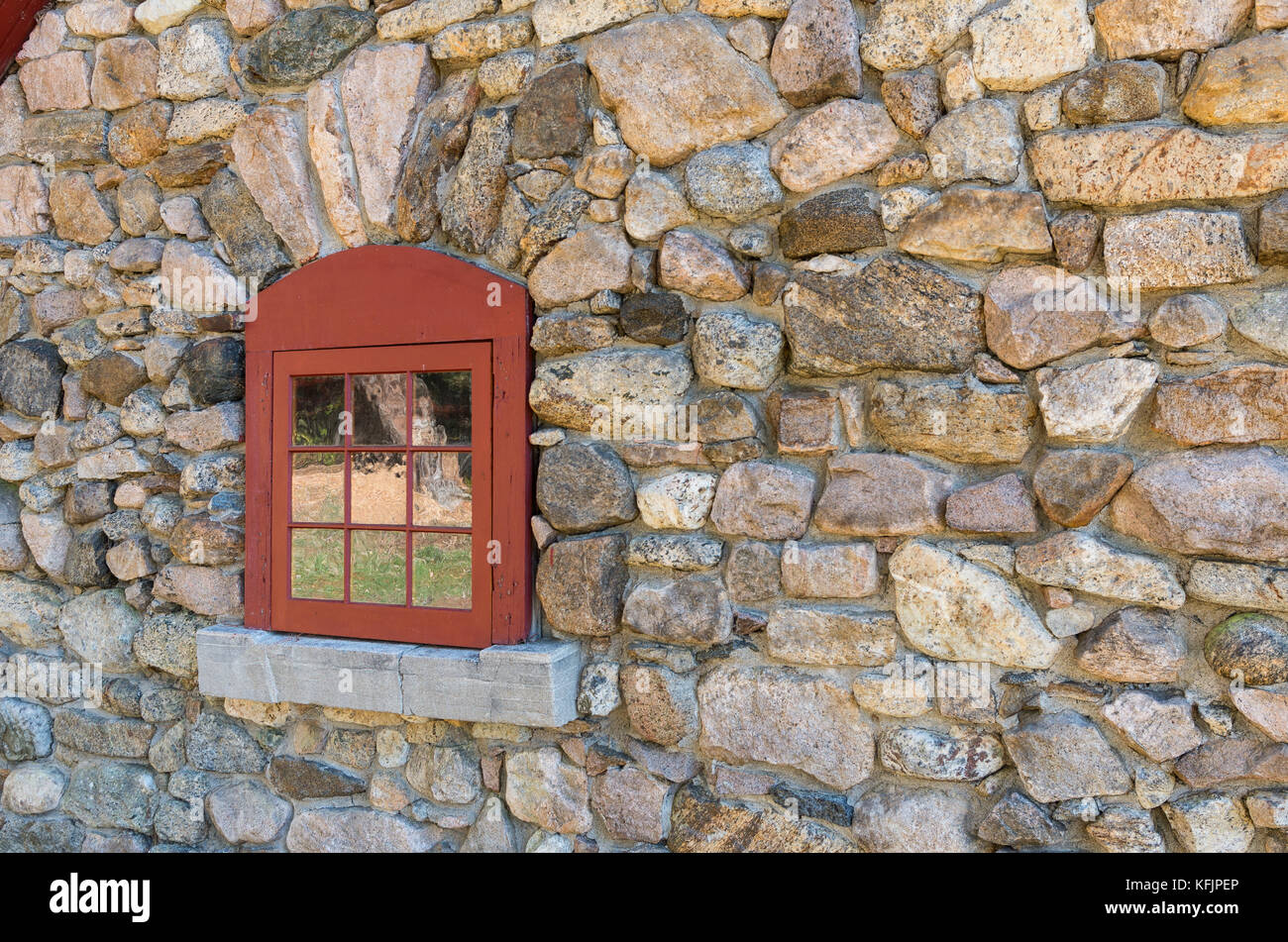 old stone farm building with red framed window with antique distorted ...