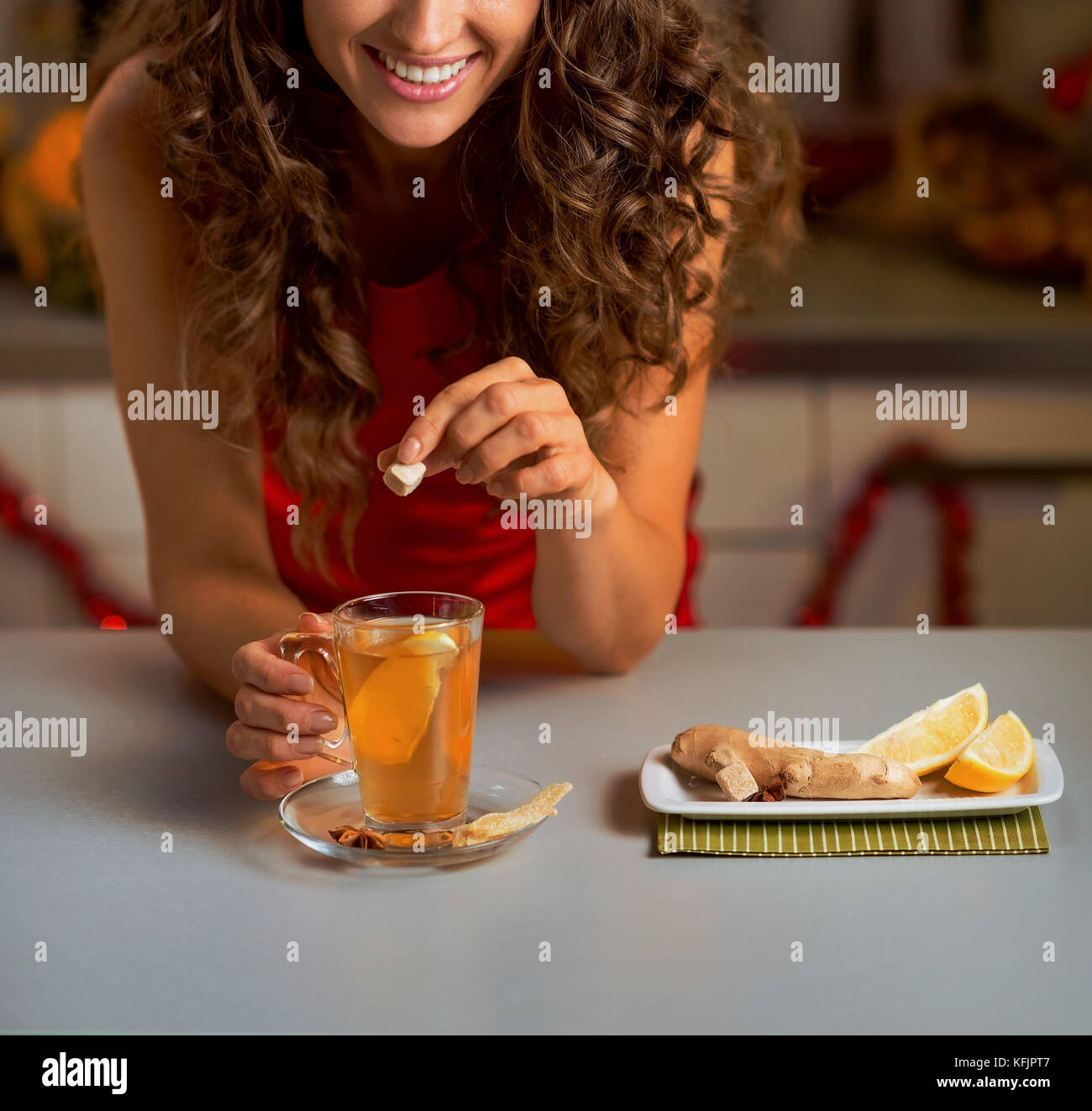 Happy young woman putting brown sugar cube into ginger tea Stock Photo ...