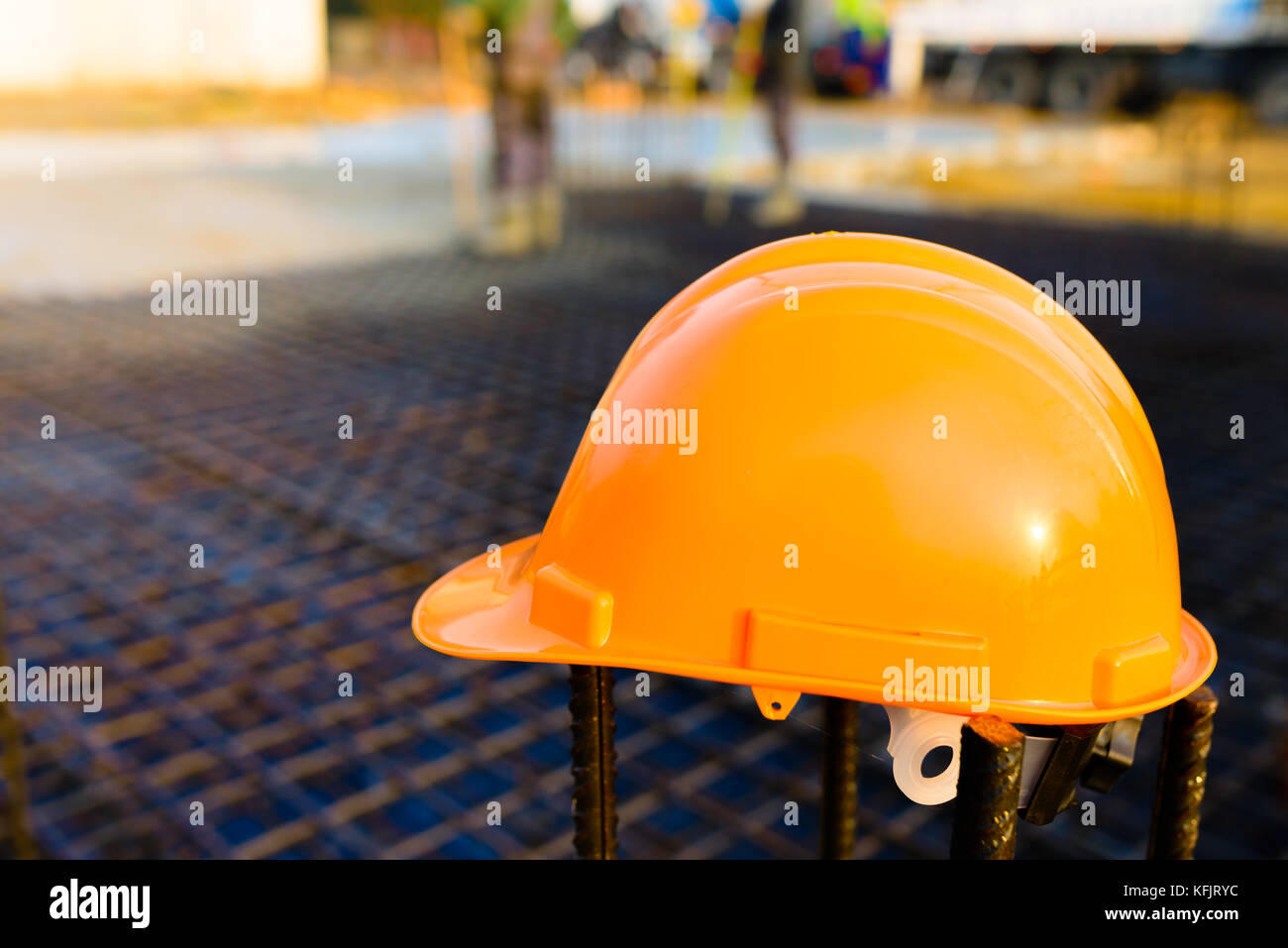 Orange safety helmet at construction site with blurry background Stock ...