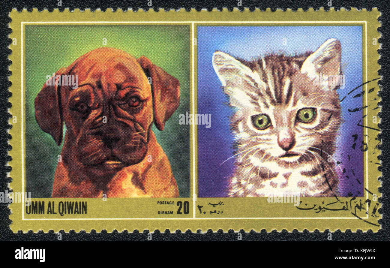 A postage stamp printed in Umm al Qiwain shows cat and dog from series ...