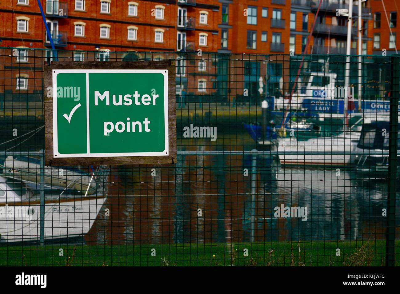 Green muster point sign at Ipswich marina on a bright autumn afternoon ...