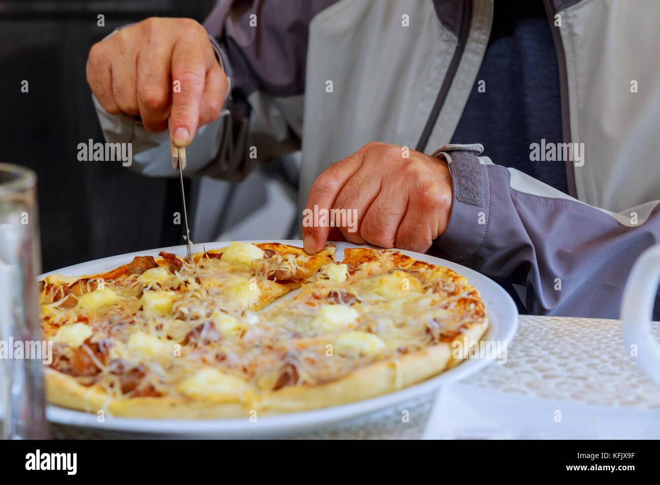 Close-up of a male chef cutting a pizza in a kitchen Stock Photo - Alamy