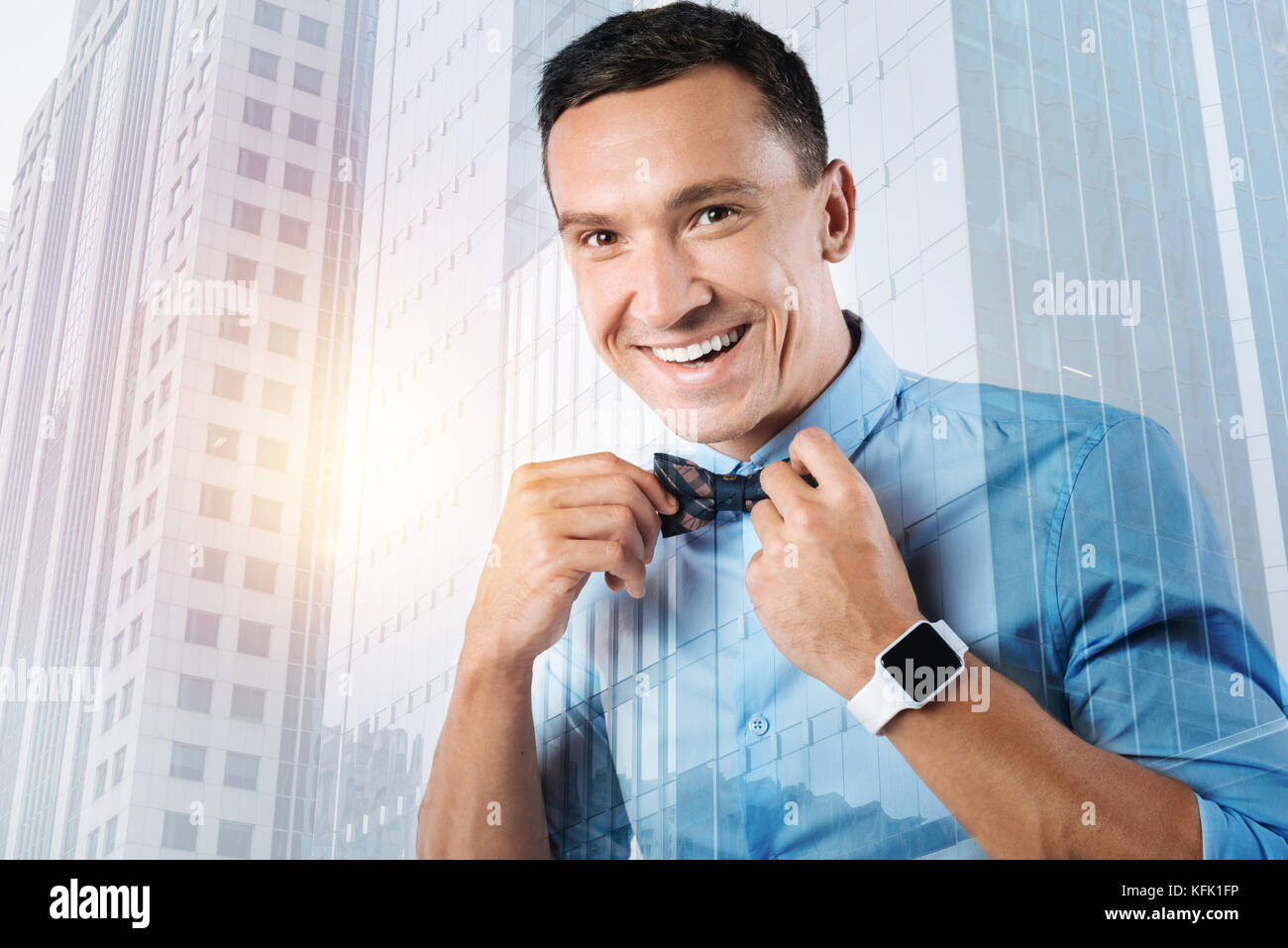 Happy cheerful man holding his bow tie Stock Photo - Alamy