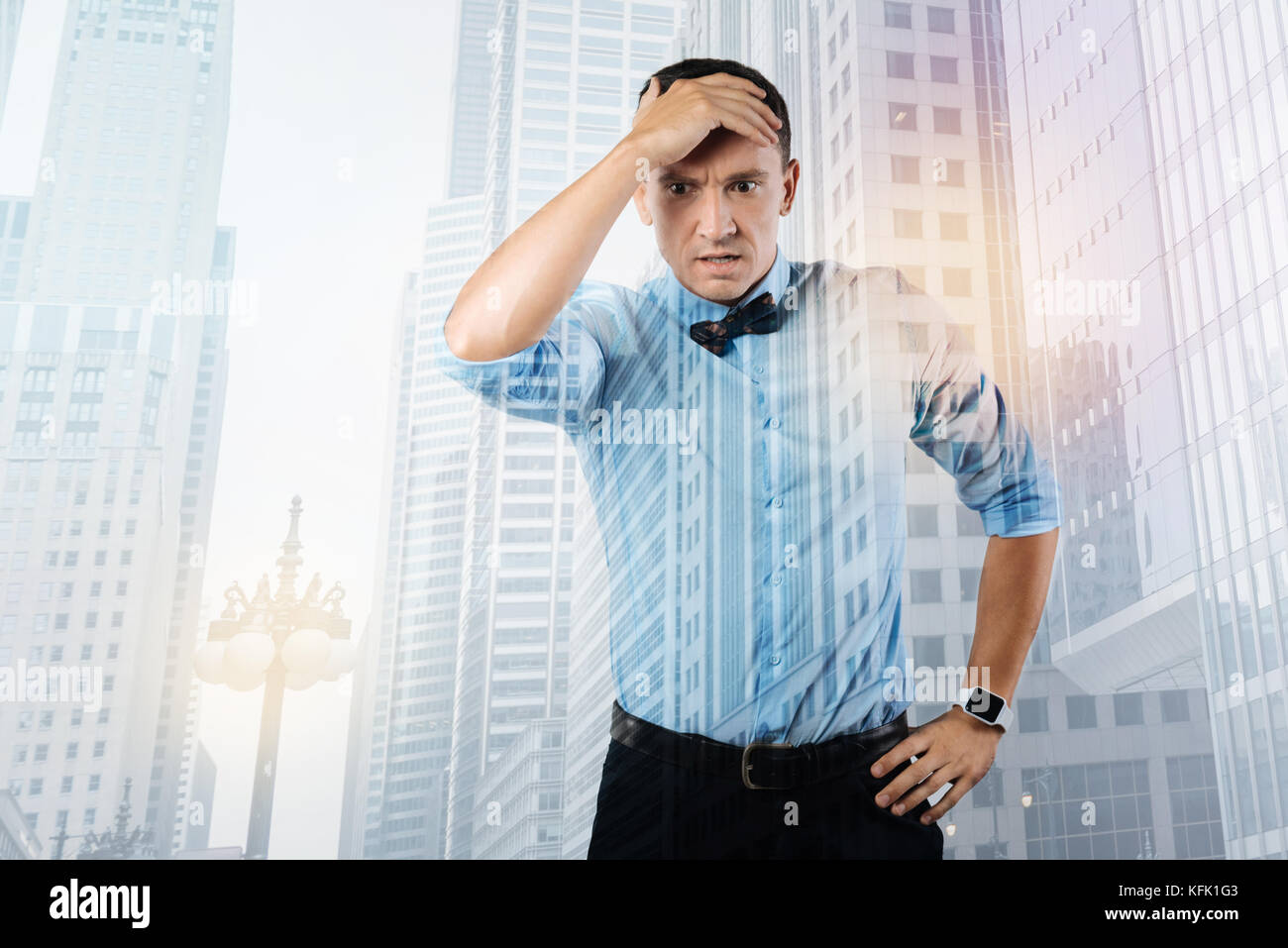 Nice handsome man holding his forehead Stock Photo - Alamy