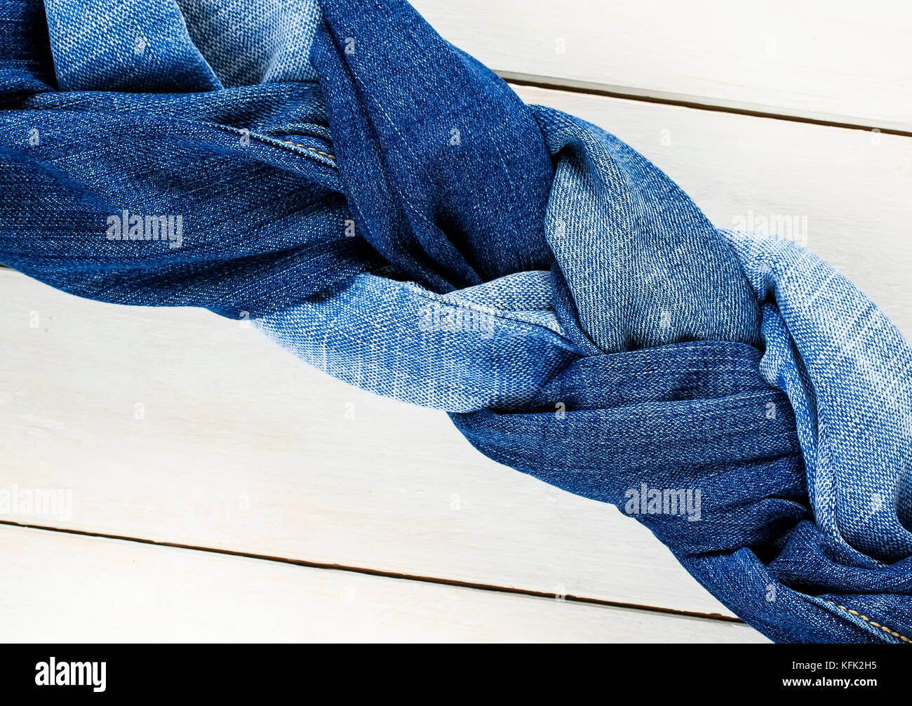 stylish and twisted braid woven from a variety of blue jeans on white ...