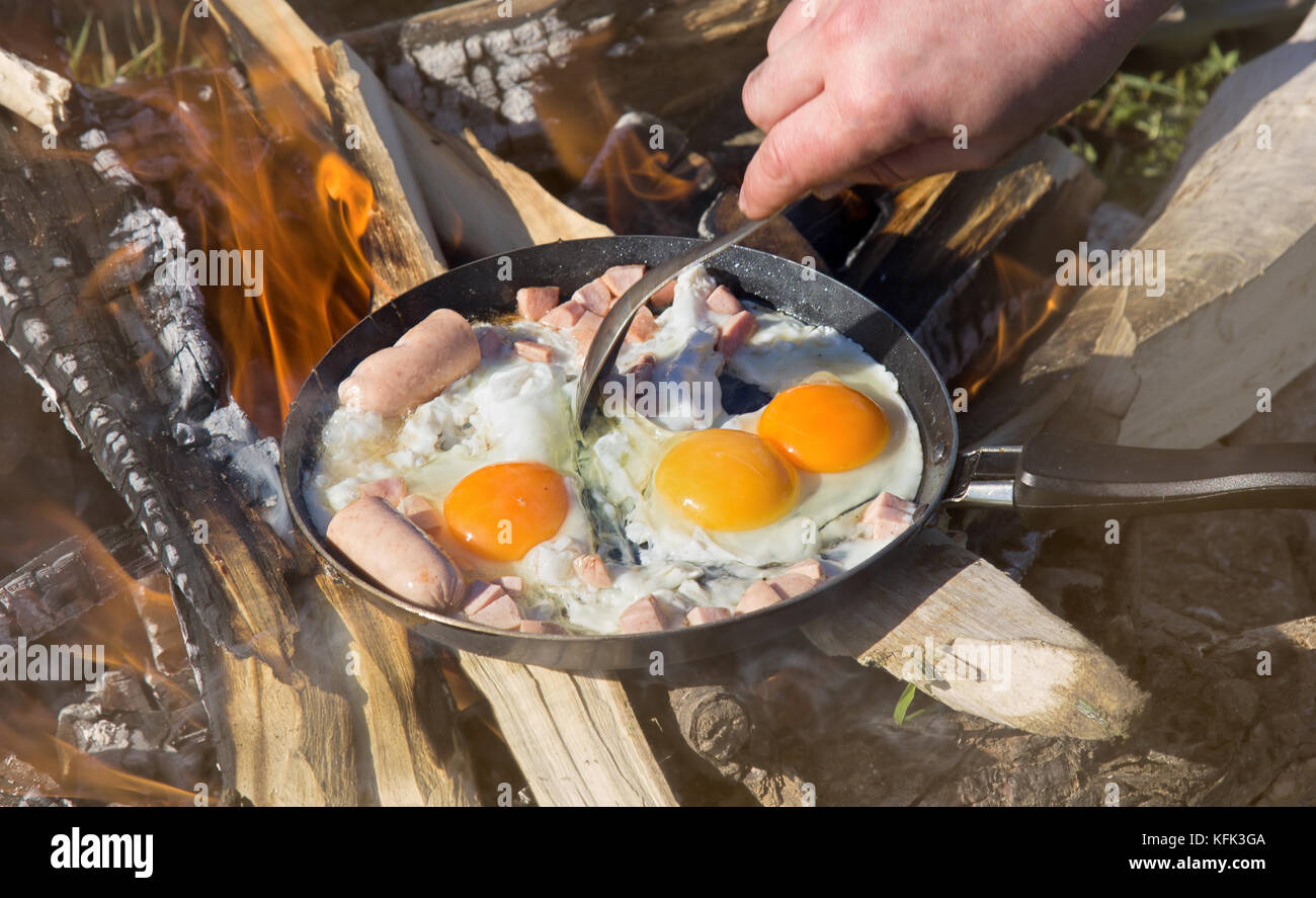 Breakfast on nature of a picnic. scrambled egg fried on coals in a pan ...