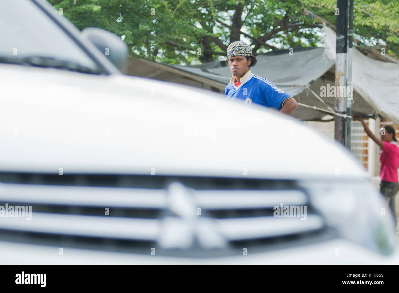 A man waits to cross a busy street in Dili, Timor-Leste (East Timor ...