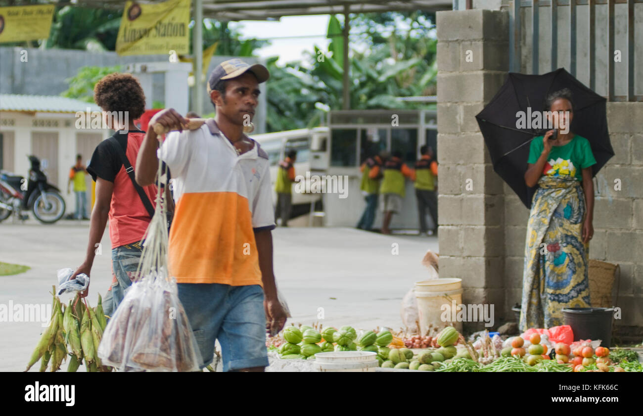 People sell a variety of fruits, vegetables, and other goods at a ...