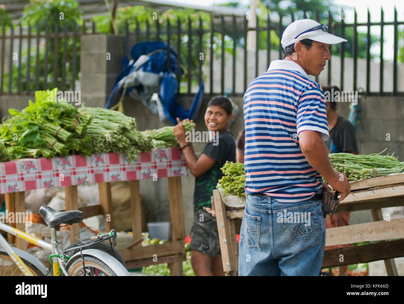 People sell a variety of fruits, vegetables, and other goods at a ...