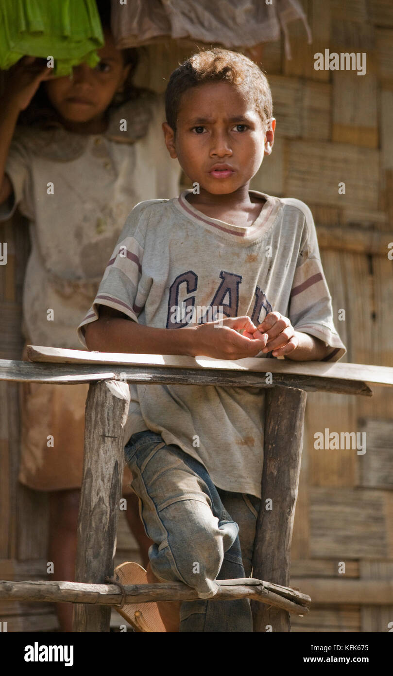 A young boy stands on the porch of his home in the Manatuto District of ...