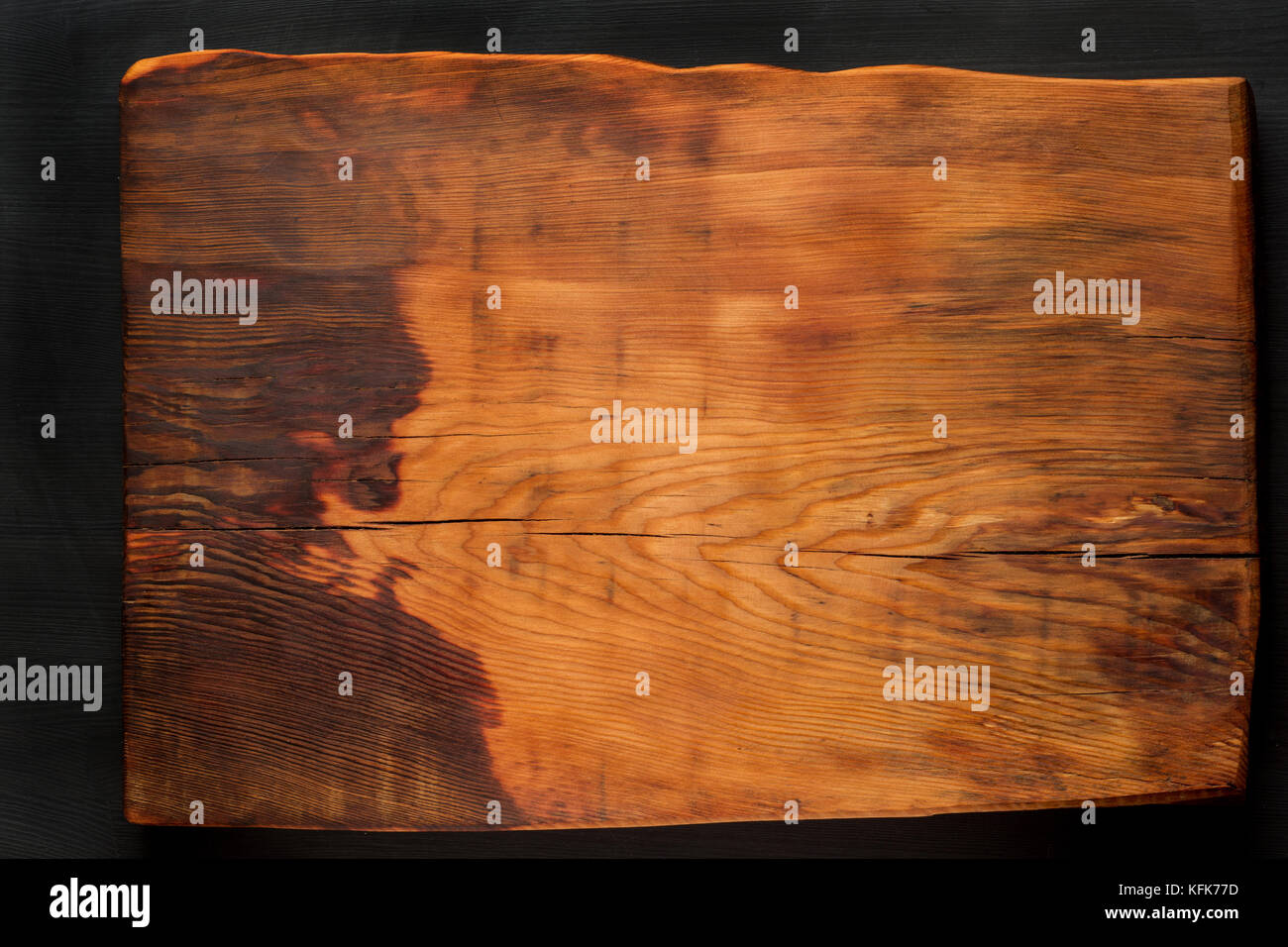 Old dark cutting board on black wooden table, background Stock Photo ...