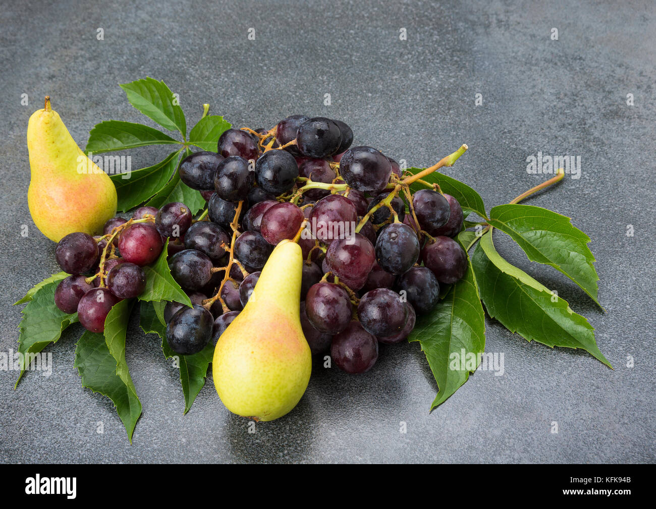 Black grapes with leaves and pears on the kitchen top Stock Photo - Alamy