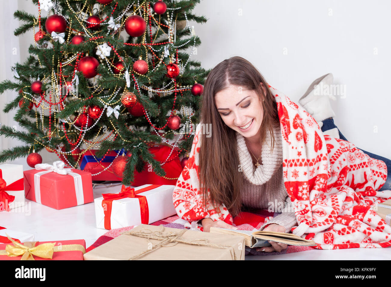 girl reading a book near the Christmas tree Christmas gifts Stock Photo ...