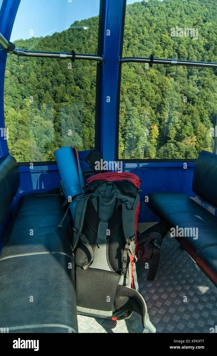 interior of the cable car gondola with a standing inside two backpacks ...