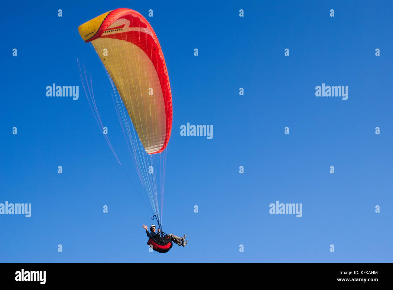 Paraglider saying hello and flying in a deep blue sky in southern ...