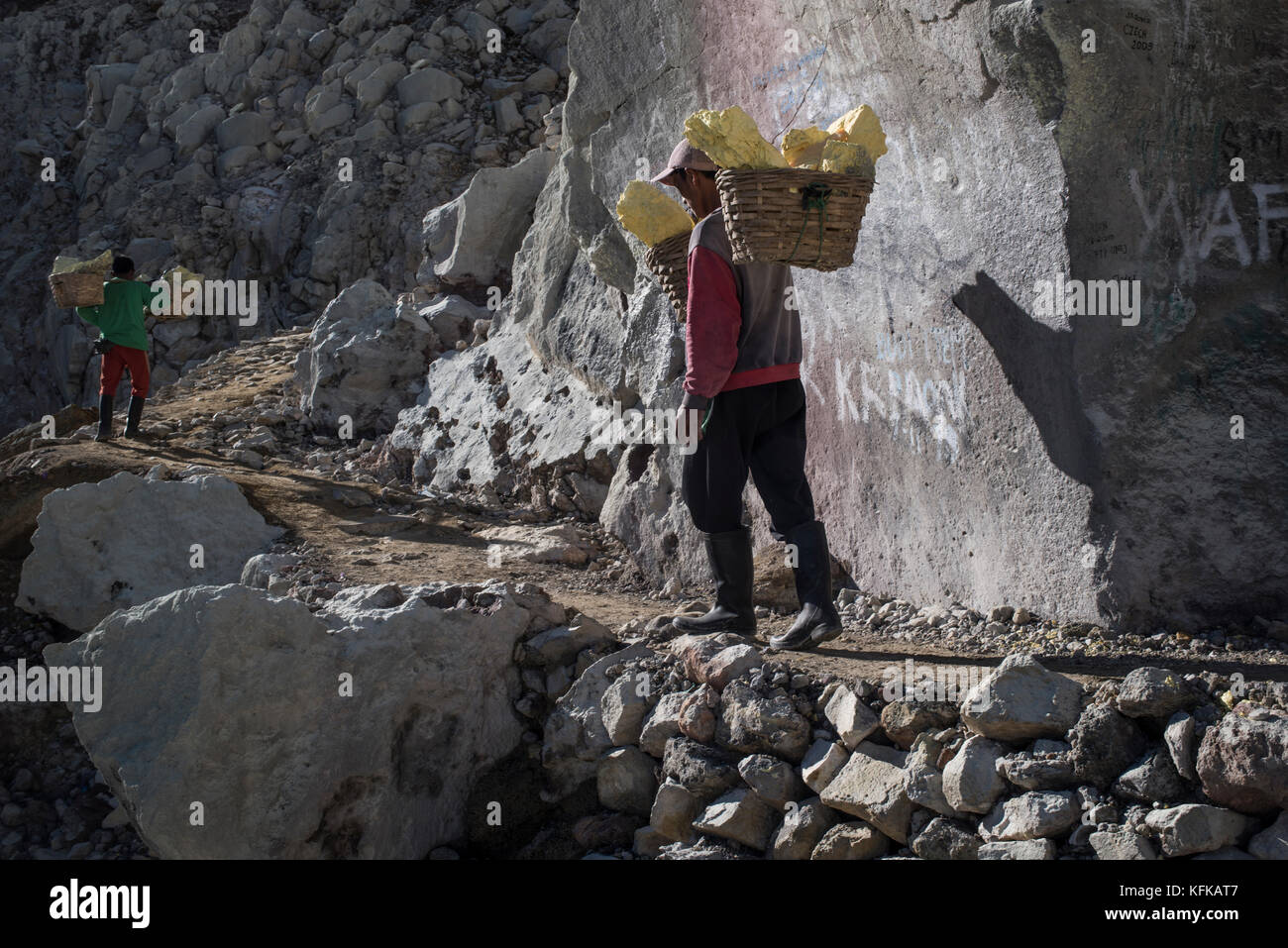 Miners carrying sulfur rocks heading up the crater Kawah Ijen Volcano ...