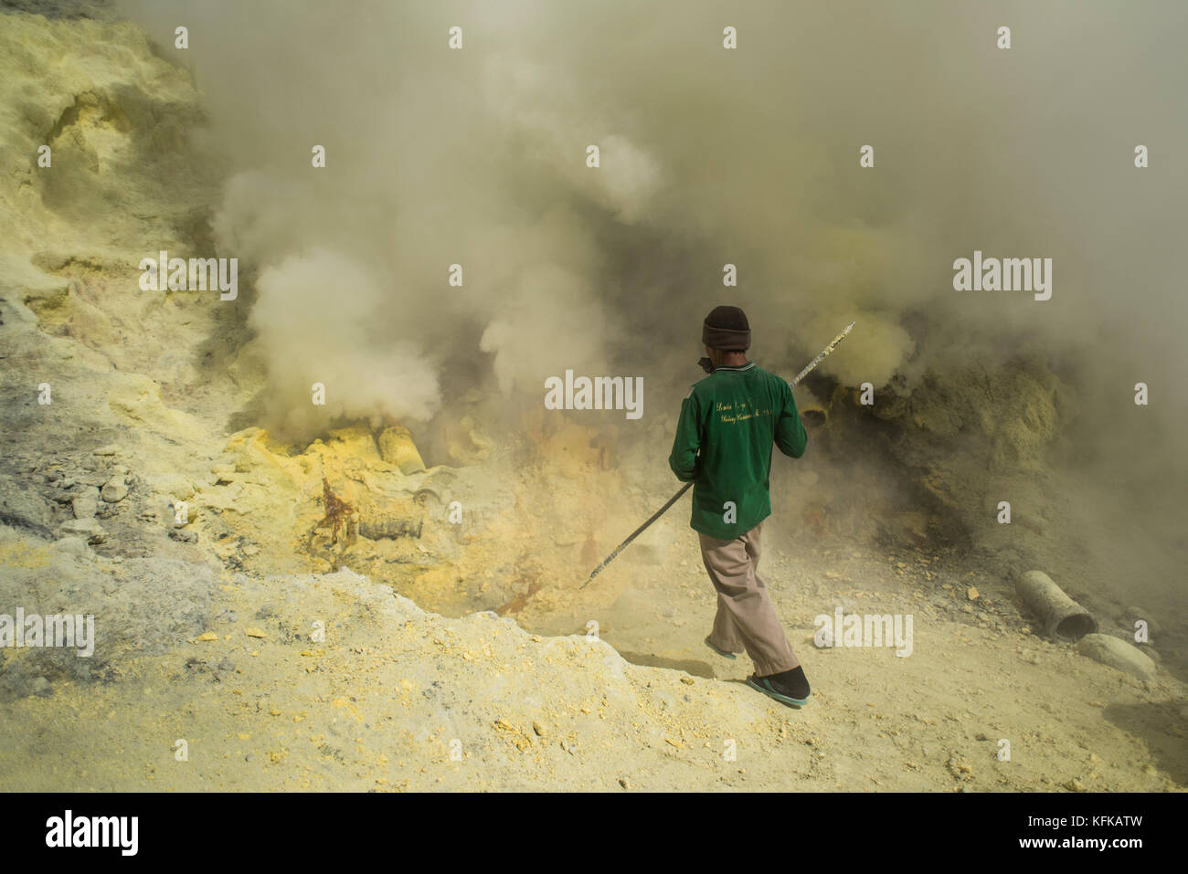 A miner extract sulfur rocks from the Kawah Ijen crater in East Java ...