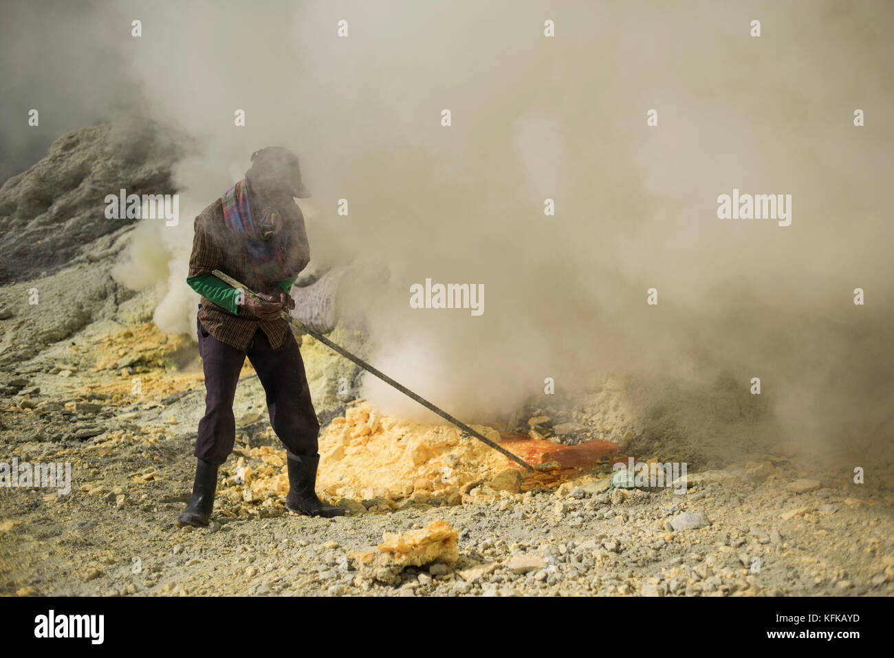A miner extracting sulfur from the Kawah Ijen Volcano crater, East Java ...