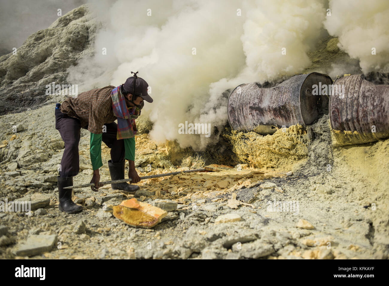 A miner extracting sulfur from the Kawah Ijen Volcano crater, East Java ...