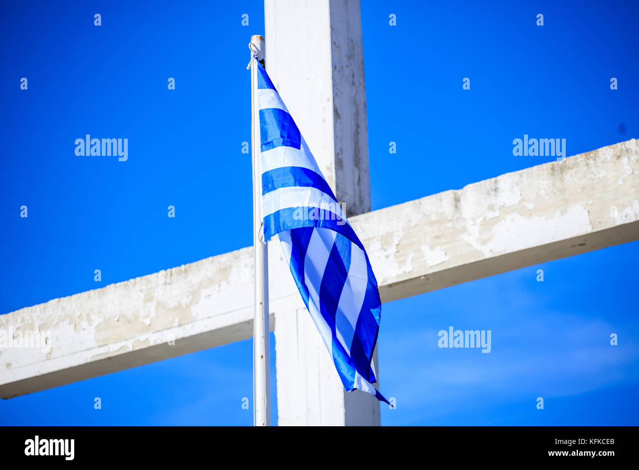 Greek flag waving on a white cross and blue sky background Stock Photo ...