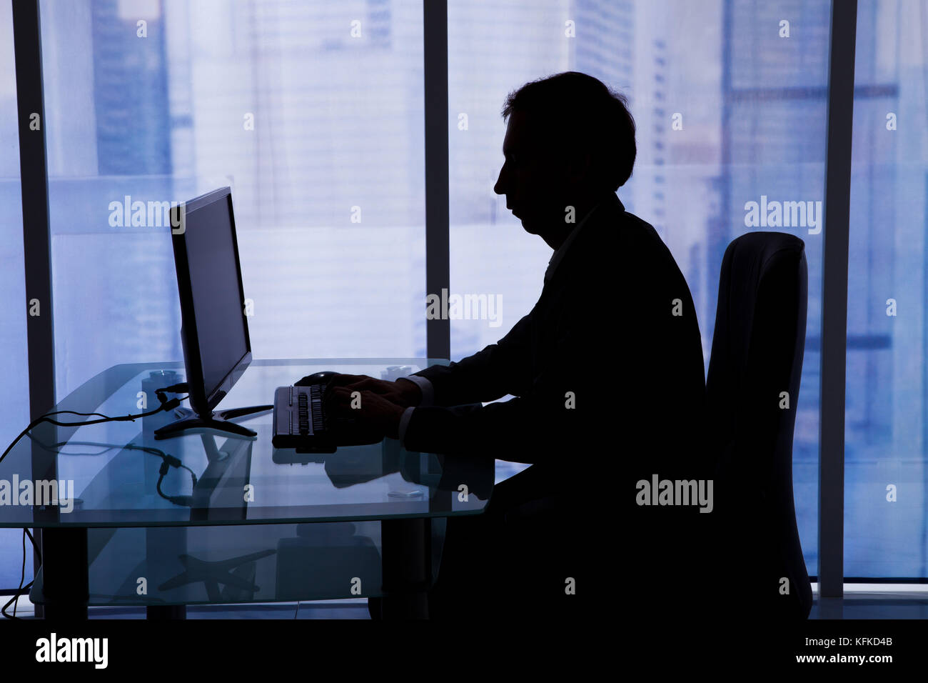 Side view of businessman using computer in office Stock Photo - Alamy