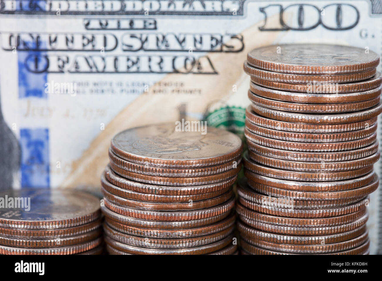 Closeup of coin stacks with hundred dollar bill Stock Photo - Alamy