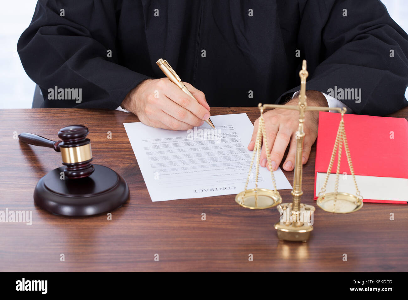 Midsection of male judge signing contract paper at desk Stock Photo - Alamy