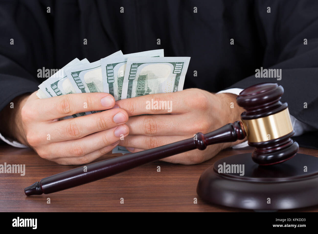 Midsection of male judge counting banknotes at desk in courtroom Stock ...