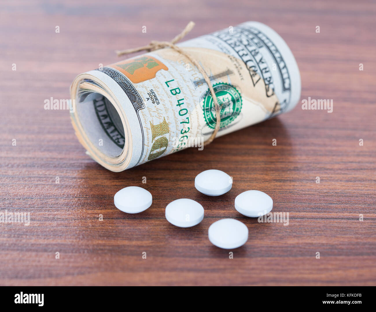 Closeup of rolled banknotes by pills on table Stock Photo - Alamy
