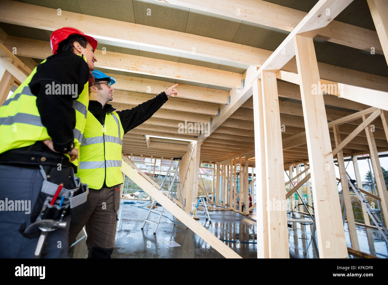 Carpenter Pointing At Roof While Standing By Colleague Stock Photo - Alamy