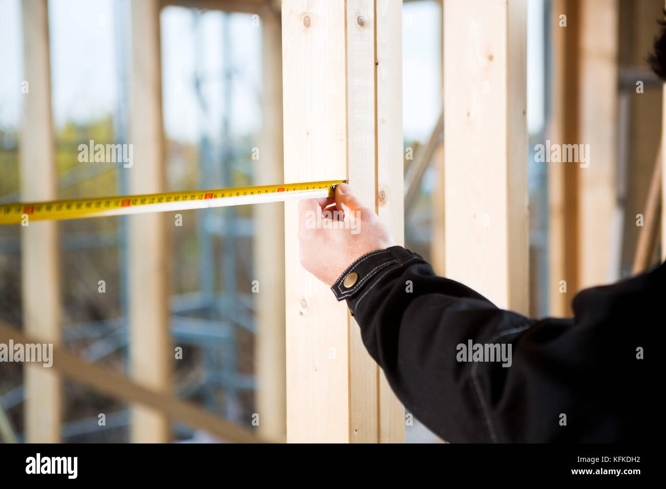 Cropped Image Of Carpenter Measuring Wood At Site Stock Photo - Alamy